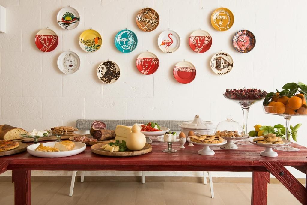 Uma mesa de jantar com diversos pratos e uma parede decorada com pratos de cerâmica.