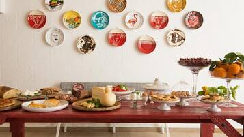 Uma mesa de jantar com diversos pratos e uma parede decorada com pratos de cerâmica.