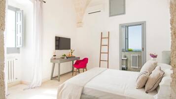 Quarto com cama, escrivaninha, cadeira, escada e janela com vista.