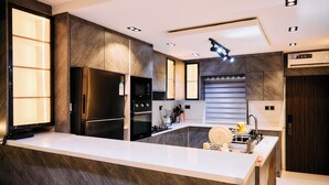 Uma cozinha moderna com uma ilha grande, eletrodomésticos embutidos e iluminação embutida.