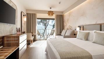 Quarto de hotel moderno com uma cama grande, uma escrivaninha, uma cadeira e uma varanda com vista para o mar.