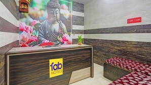 Uma receção com uma estátua de Buda, um relógio e um balcão de check-in na Fab Hotels.