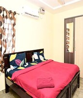 Quarto com cama, guarda-roupa e ar condicionado.