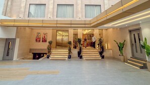 Um hotel com fachada moderna, janelas amplas e entrada central com degraus.