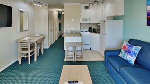 Um espaço compacto com cozinha compacta, área de refeições e espaço de estar.