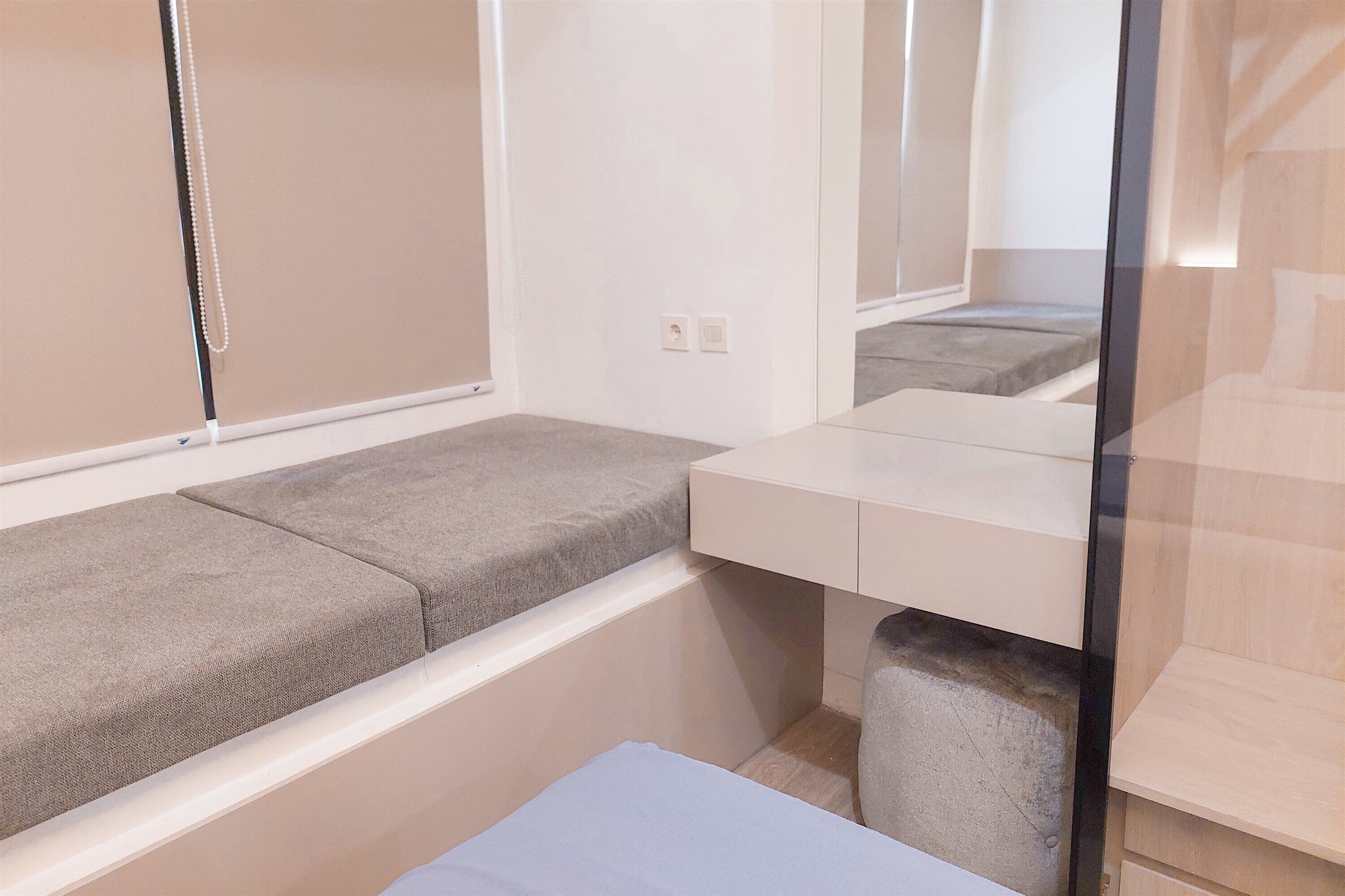 Uma casa de banho moderna com um banco, um espelho e uma pia branca.