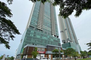 Um edifício moderno de muitos andares com janelas de vidro refletivo e um andar térreo comercial.
