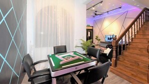 Um quarto com mesa de bilhar, escada e design moderno no teto.