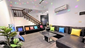 Uma sala de estar moderna com um conjunto de sofás, uma mesa de centro e uma escada.