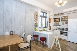 Uma cozinha moderna com mesa de jantar de madeira, dois banquetes e uma ilha central.