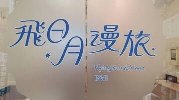 Paredes com logotipo e o nome 'Flying Sun & Moon B&B', identificando um estabelecimento de cama e café.