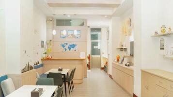 Quarto de hotel com área de refeições, cozinha e balcão de recepção.