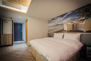Quarto com cama, cabeceira com mural de praia, piso de madeira e porta que dá para outro cômodo.