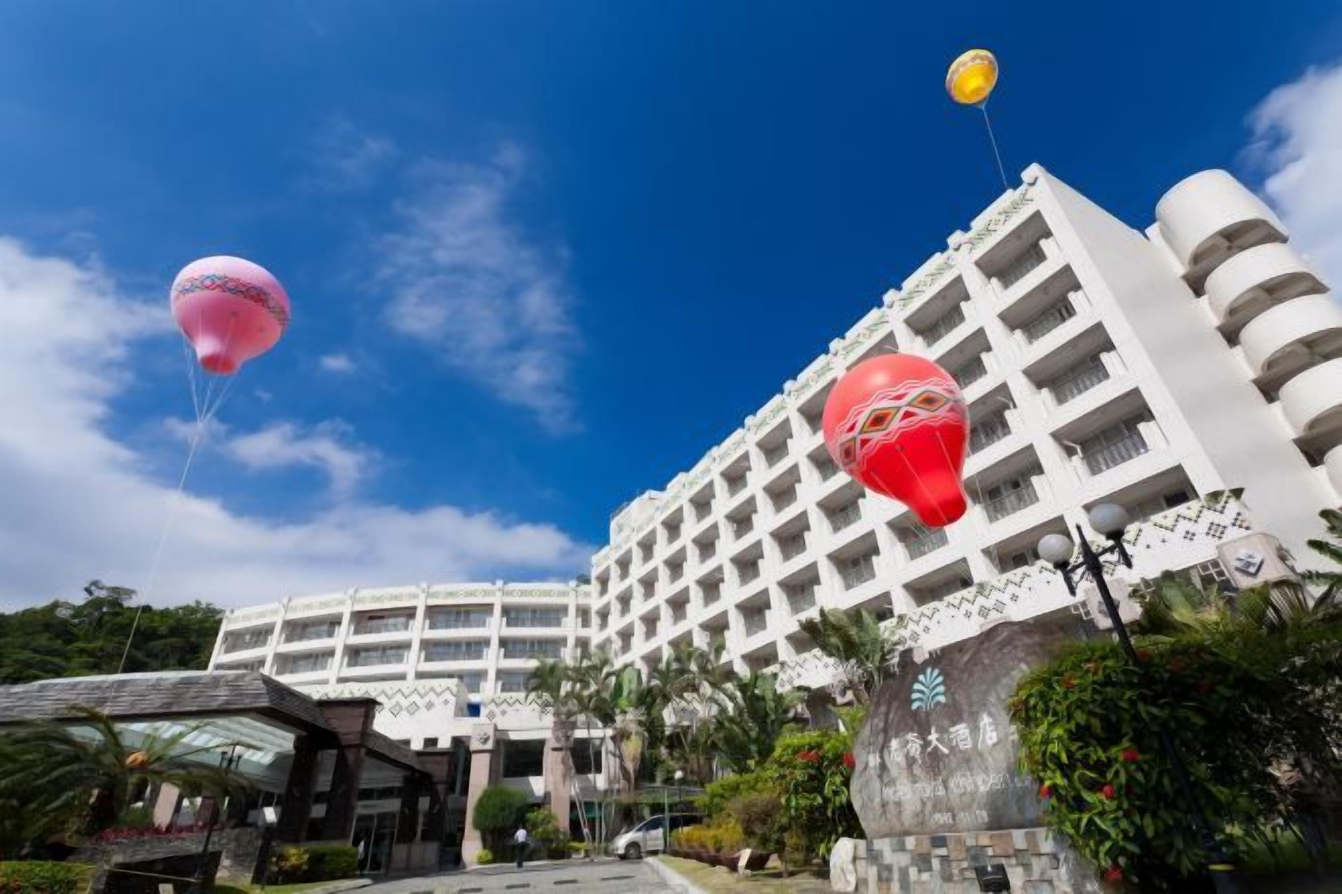Um hotel com vários andares, uma entrada espaçosa e céu claro.