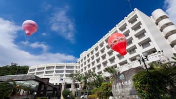 Um hotel com vários andares, uma entrada espaçosa e céu claro.