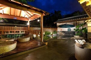 Uma área externa coberta com assentos de madeira e uma pequena piscina.