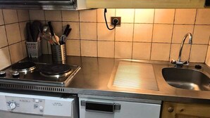 Uma cafeteira/bule, um micro-ondas, um forno 
