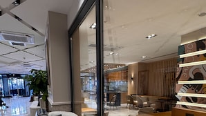Um interior moderno com área de estar, uma mesa de jantar e vista para o espaço adjacente.