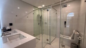 Um banheiro moderno com chuveiro envidraçado, pia grande e vaso sanitário.