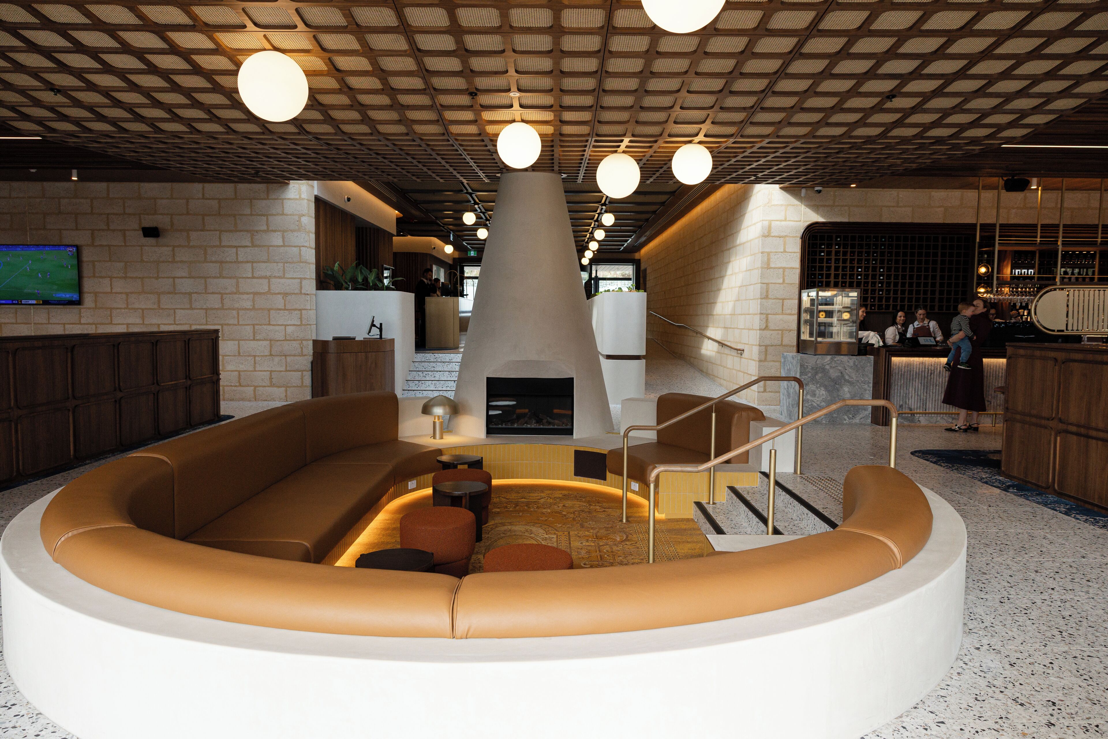 Um interior moderno com uma área de estar circular, um balcão de recepção e um bar.