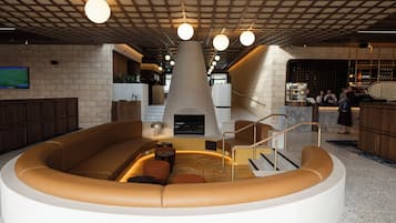 Um interior moderno com uma área de estar circular, um balcão de recepção e um bar.