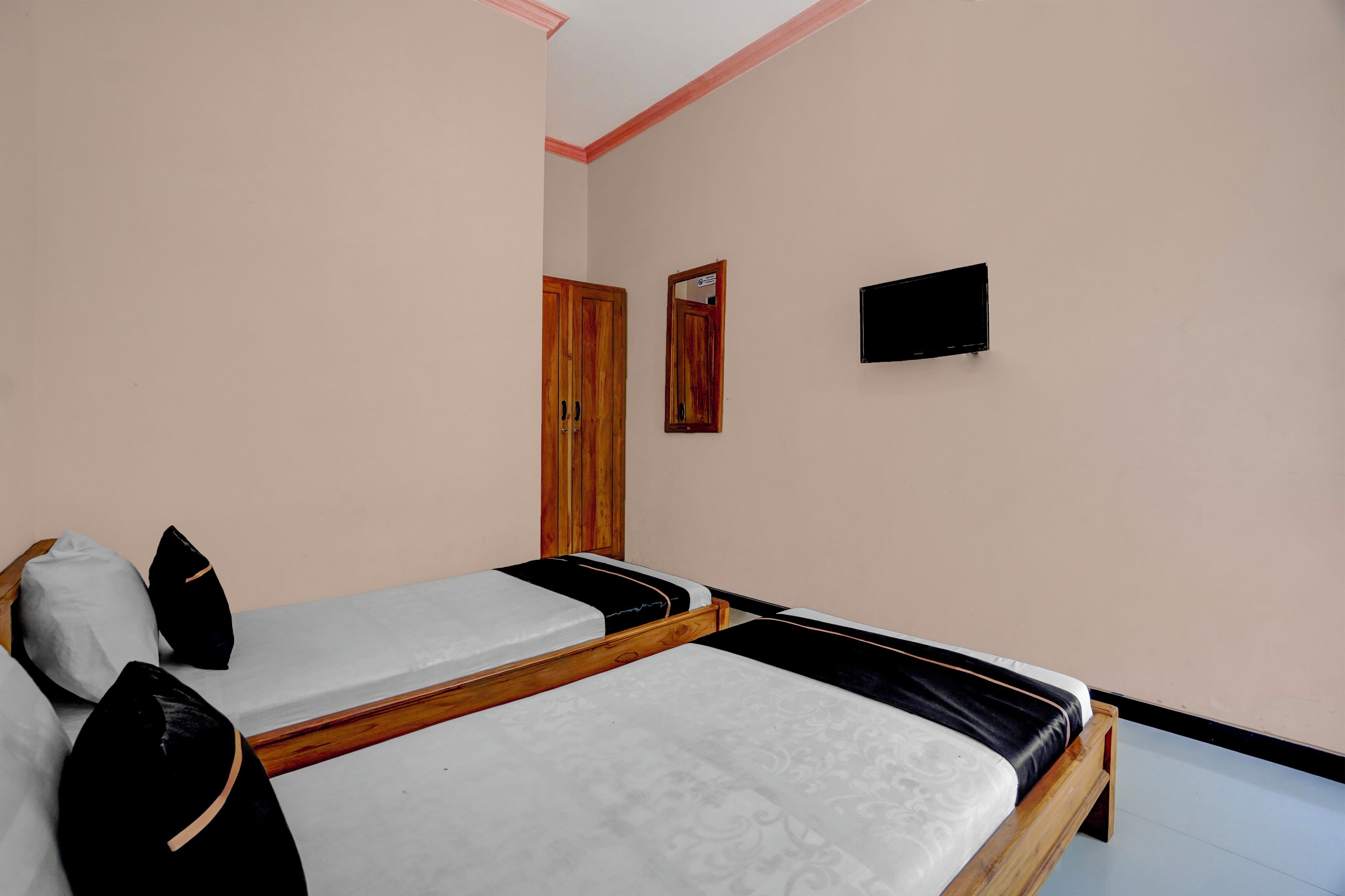Quarto com cama, guarda-roupa e televisão na parede.