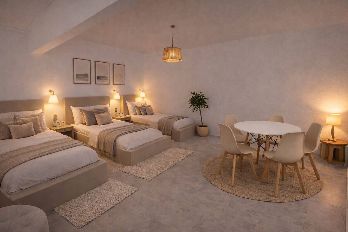 Quarto moderno com duas camas, uma mesa de jantar, cadeiras, um lustre e um vaso com planta.