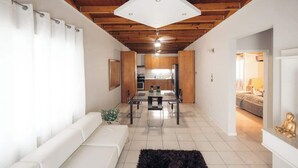 Cozinha moderna com armários de madeira e área de refeições com mesa e cadeiras.