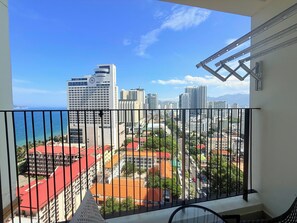 Varanda com vista para a paisagem urbana, incluindo edifícios altos e um corpo de água.