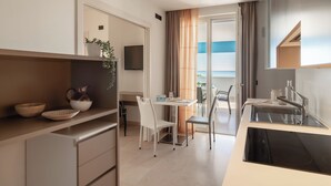 Uma cozinha moderna com área de jantar, televisão e vista para o mar.