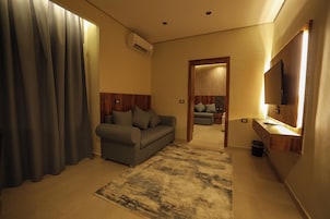 Suite-Estúdio Deluxe, Vista para a cidade | Sala de estar | Televisor LED de 42 polegadas com canais via satélite, Netflix