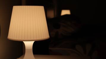 Abajur com cúpula texturizada sobre uma mesa branca.