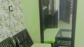 Quarto com sofá, mesa de centro de vidro e um espelho grande.