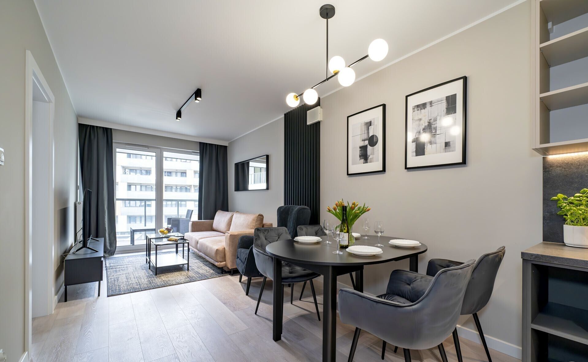 Uma sala de estar moderna com área de jantar, apresentando um sofá, cadeiras, uma mesa de centro e uma mesa de jantar posta para quatro pessoas.