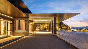 Um edifício moderno com uma galeria coberta e vista para a paisagem ao redor.
