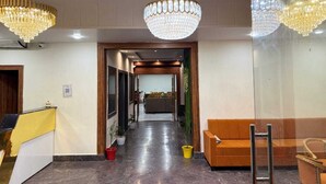 Uma área de recepção com balcão, um banco de madeira e uma escadaria para outro espaço.