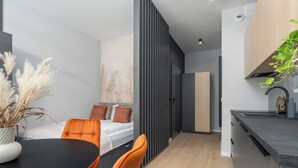 Um quarto moderno com cama, mesa de cabeceira e um vaso com planta.