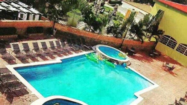 Uma área de piscina com vários espaços de estar e uma piscina central.