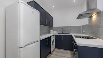 Um frigorífico, um micro-ondas, um forno, uma placa de cozinha