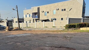 Um edifício moderno com fachada plana, várias janelas e uma varanda visível.