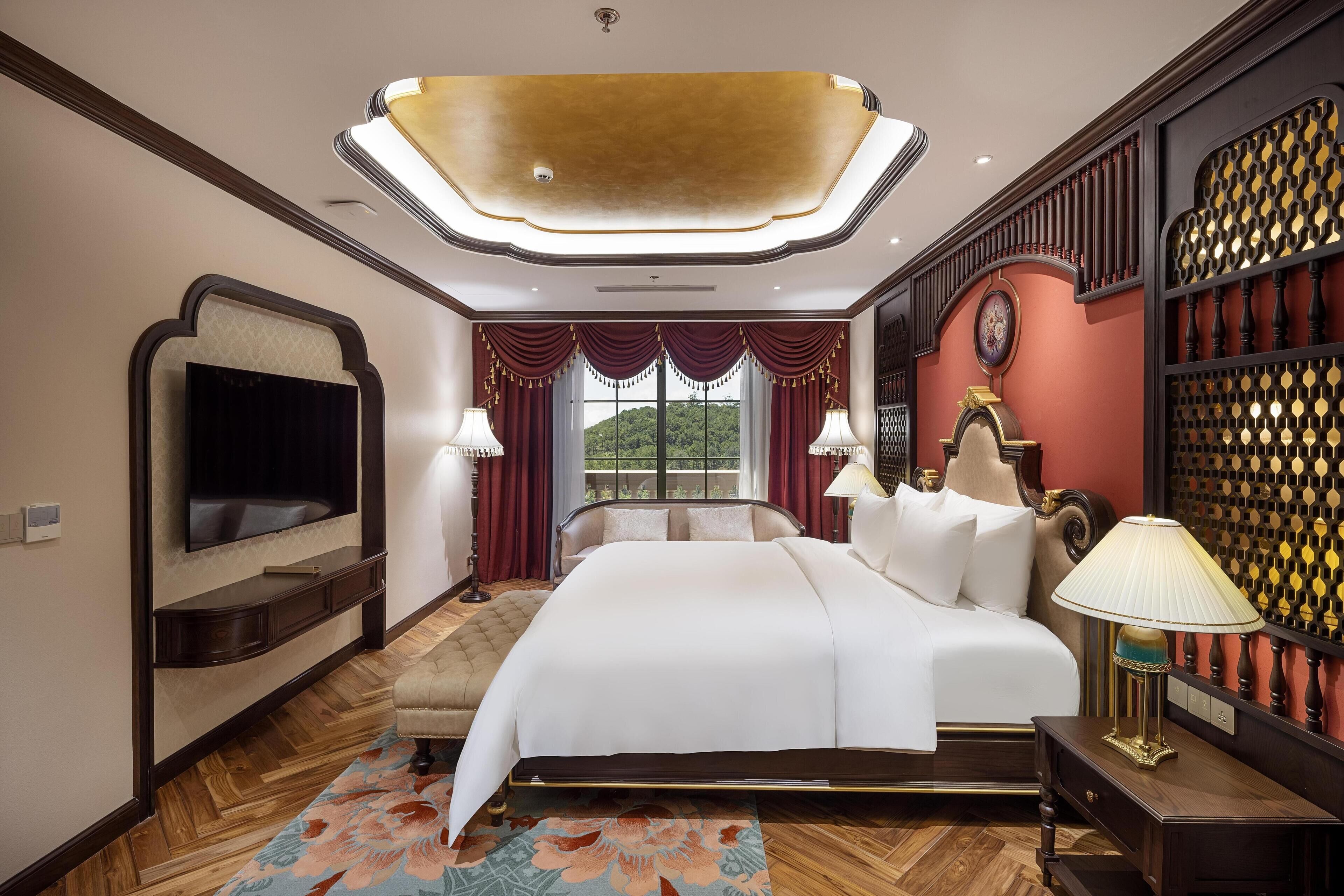 Um quarto espaçoso com uma cama grande, televisão na parede e um painel decorativo.