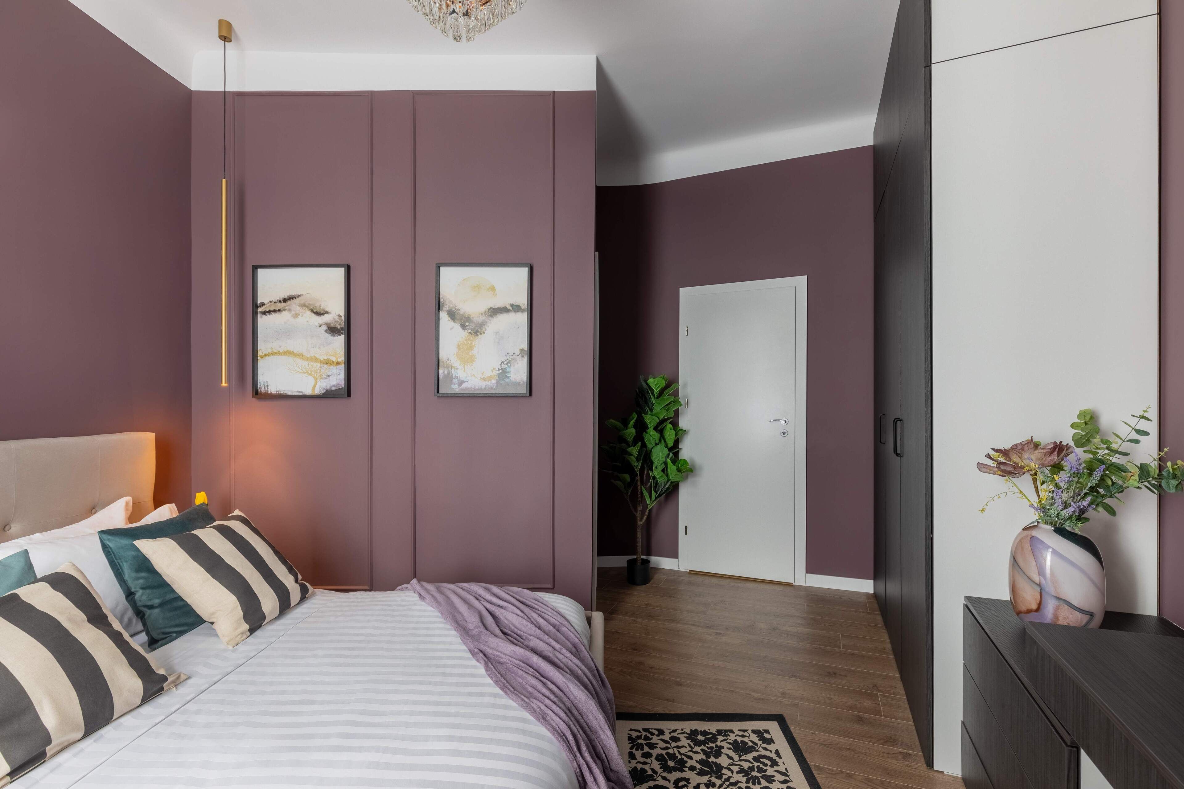 Um quarto moderno com cama, mesa de cabeceira, cômoda e planta em vaso.