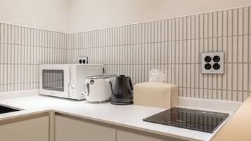 Um micro-ondas, uma placa de cozinha, utensílios de cozinha