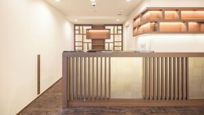Um balcão de recepção com design moderno, revestido em madeira e com iluminação integrada.