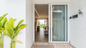 Interior moderno com porta de vidro deslizante para uma sala de jantar, planta em vaso e unidade de ar condicionado na parede.