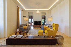 Uma sala de estar moderna com sofá, poltrona, mesa de centro e televisão.