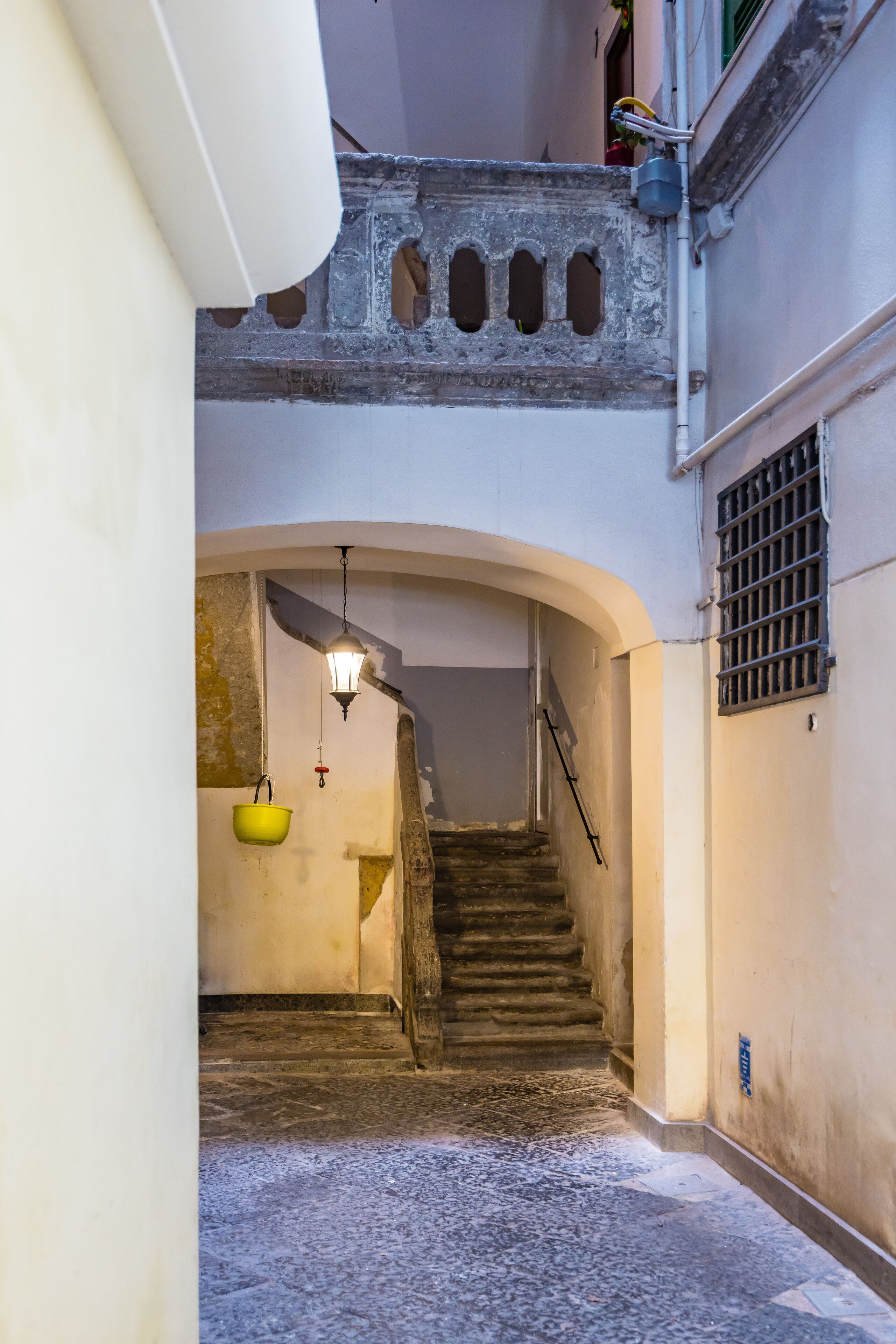 Um beco estreito com uma escadaria de pedra que leva a um andar superior.