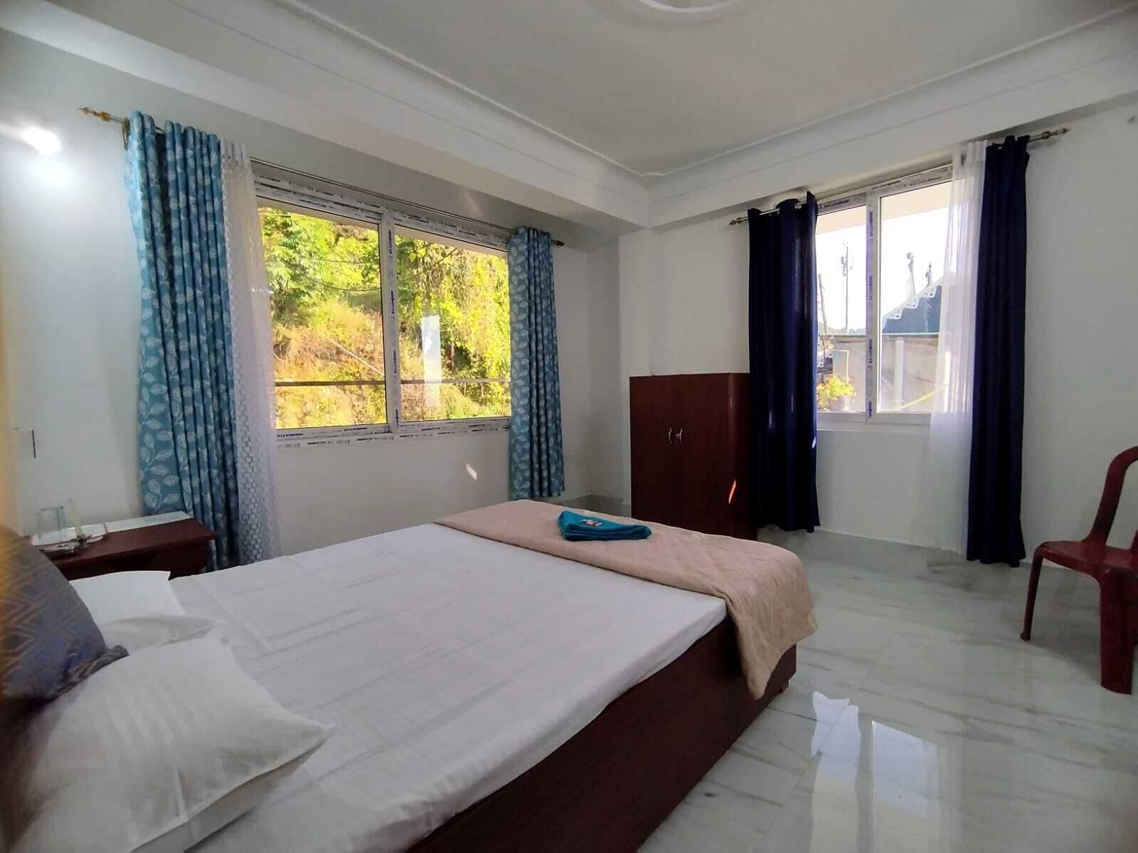 Quarto com cama, guarda-roupa, escrivaninha e cadeira.
