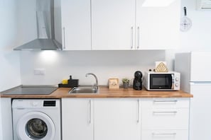 Um frigorífico/congelador grande, um micro-ondas, uma placa de cozinha