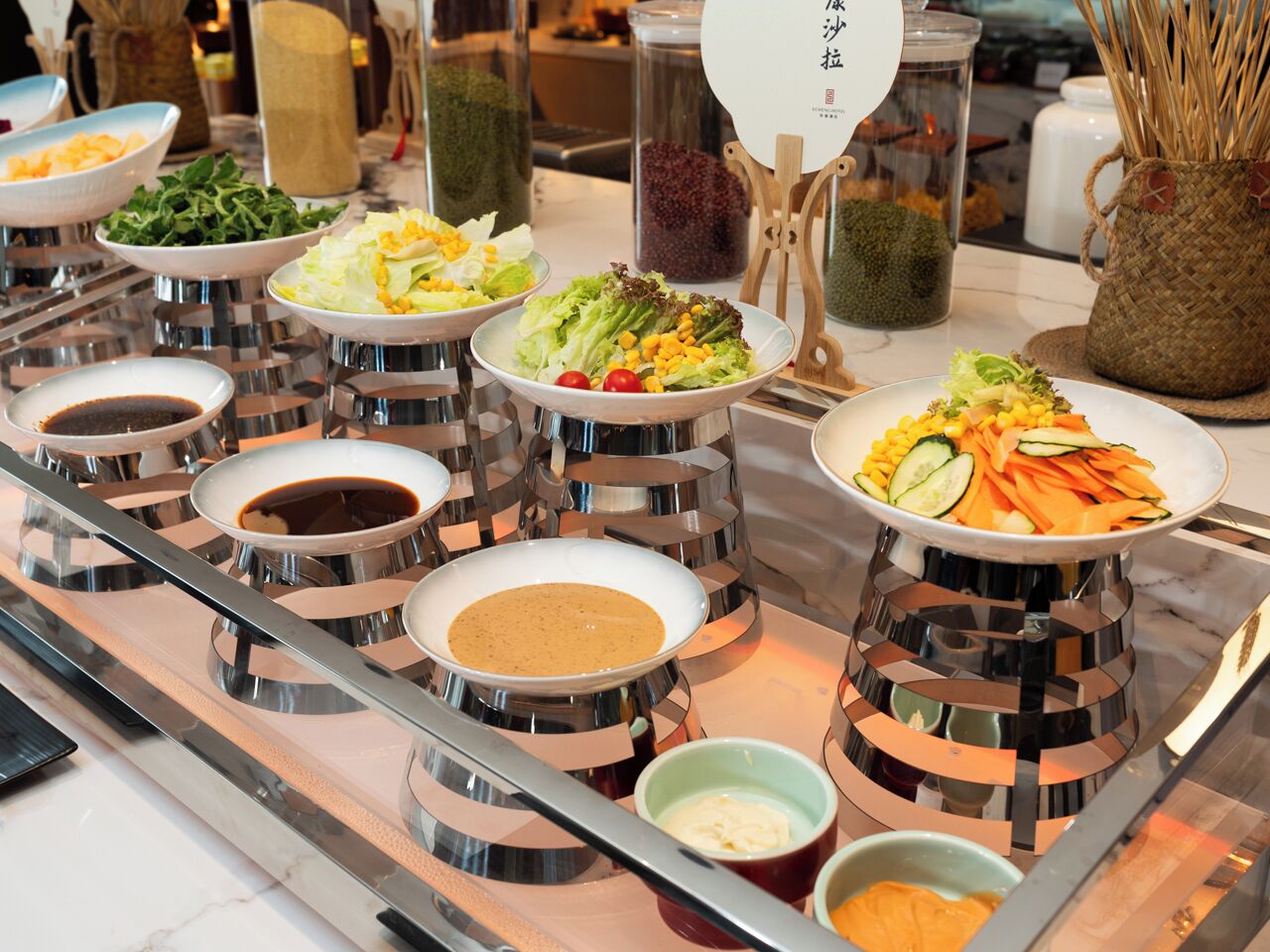 Buffet com diversos pratos e molhos.